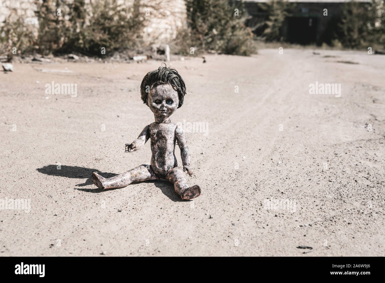 shadow near old and scary baby doll on ground, post apocalyptic concept ...