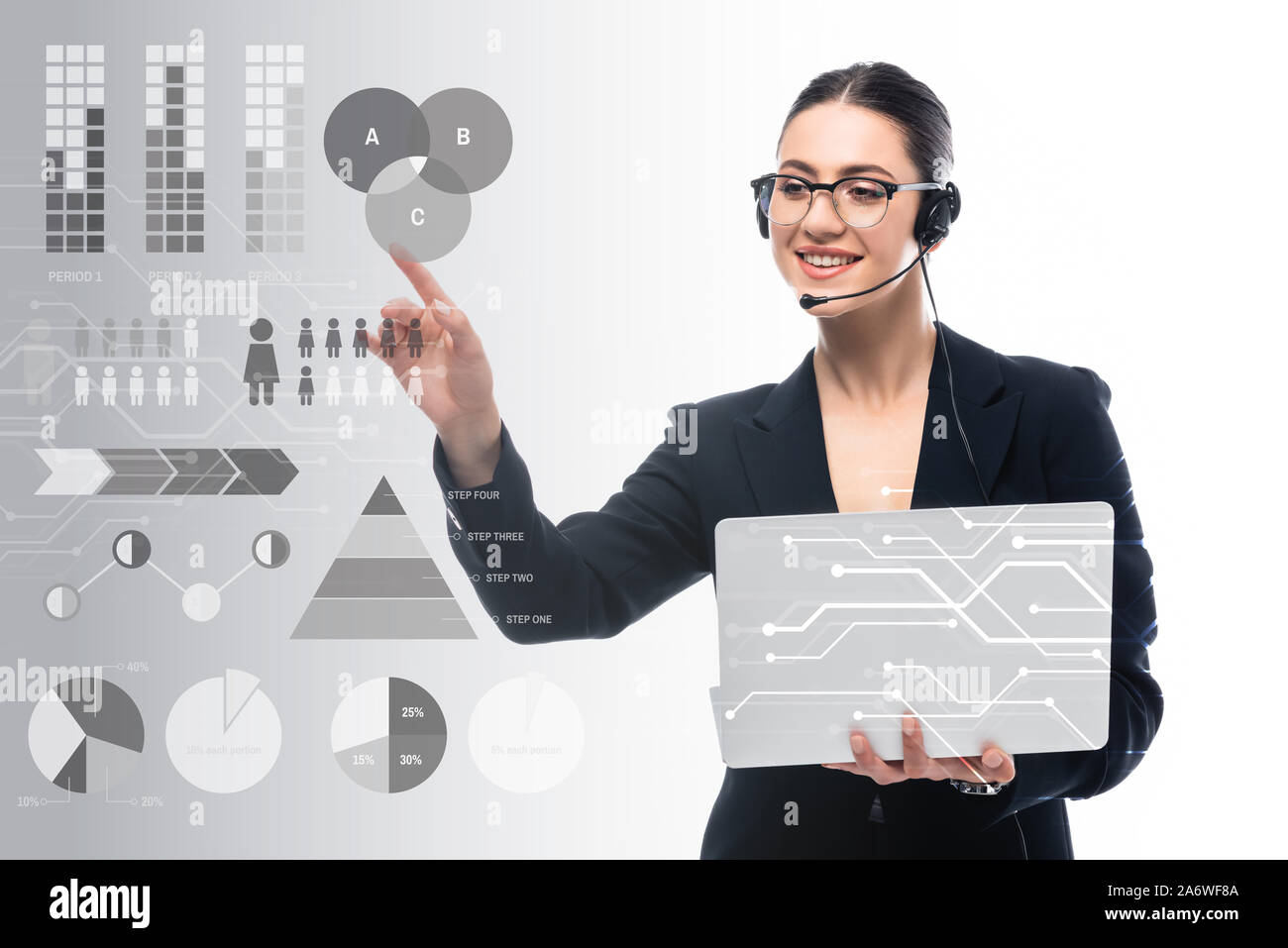 attractive call center operator holding laptop and pointing with finger ...