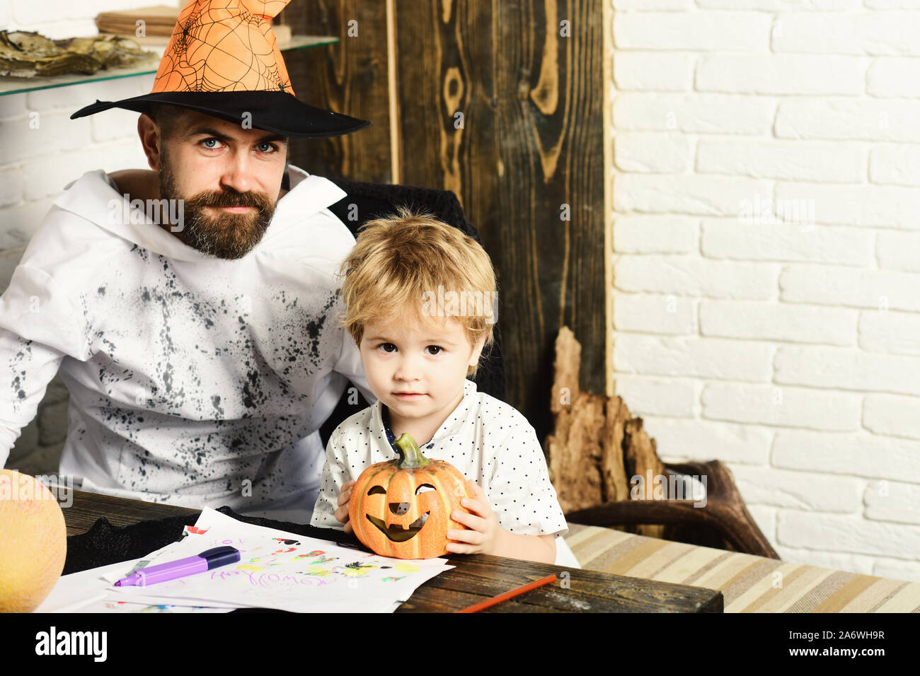 Guy and boy on wooden and white brick wall background. Witcher and ...