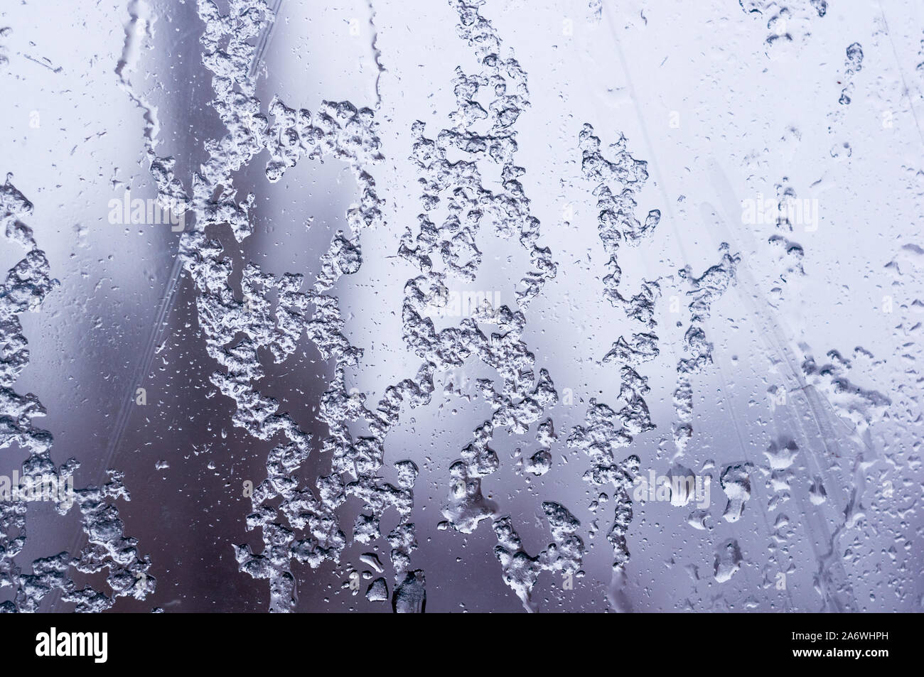 glass in the window covered with wet melting snow, close-up, macro ...