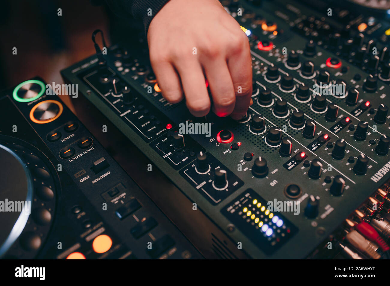 Closeup fingers shot of Dj controling red party dj audio equipment ...