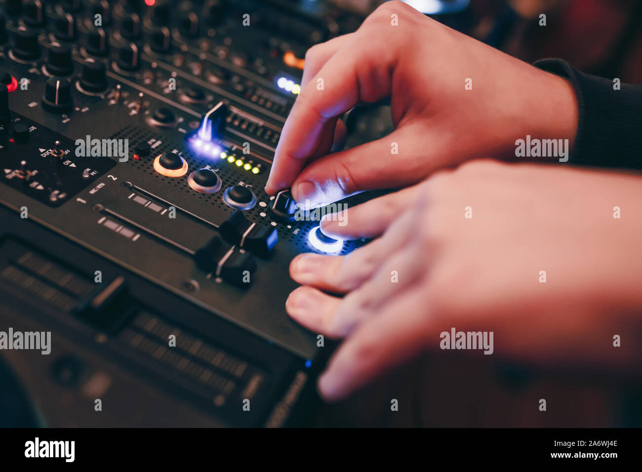 Closeup fingers shot of Dj controling red party dj audio equipment ...