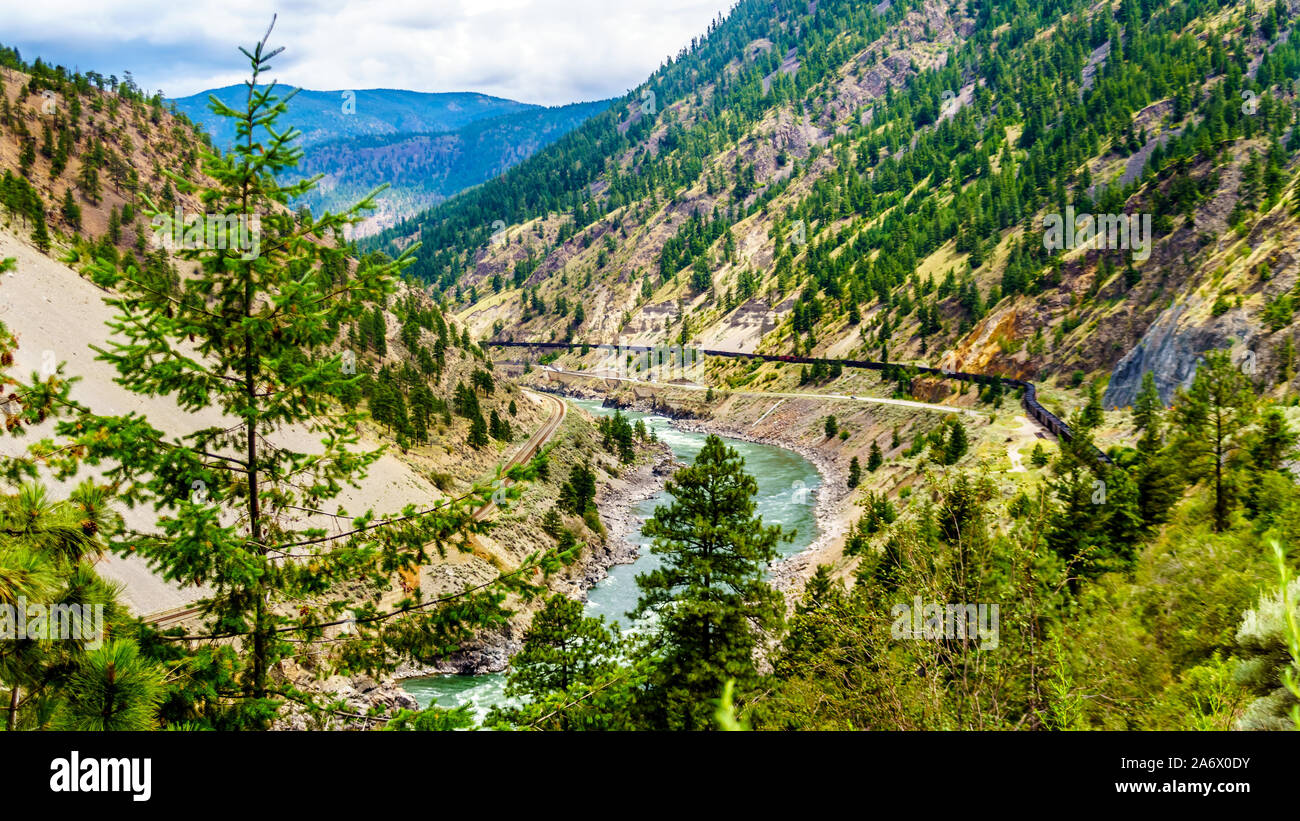 Freight train on the railroad tracks running along the mighty Fraser ...