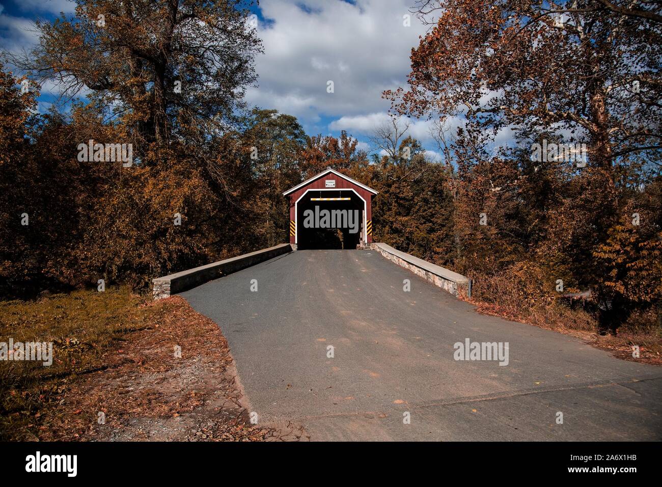 A horizontal shot of a cover bridge in the forest surrounded by ...
