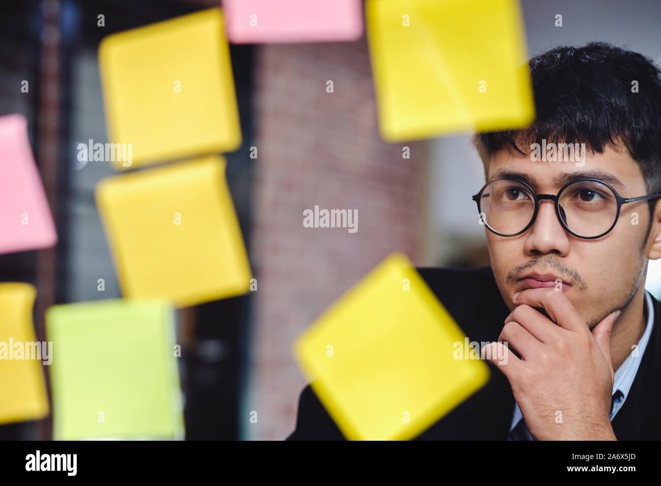 asian businessman looking and writing on sticky note for brainstorming ...