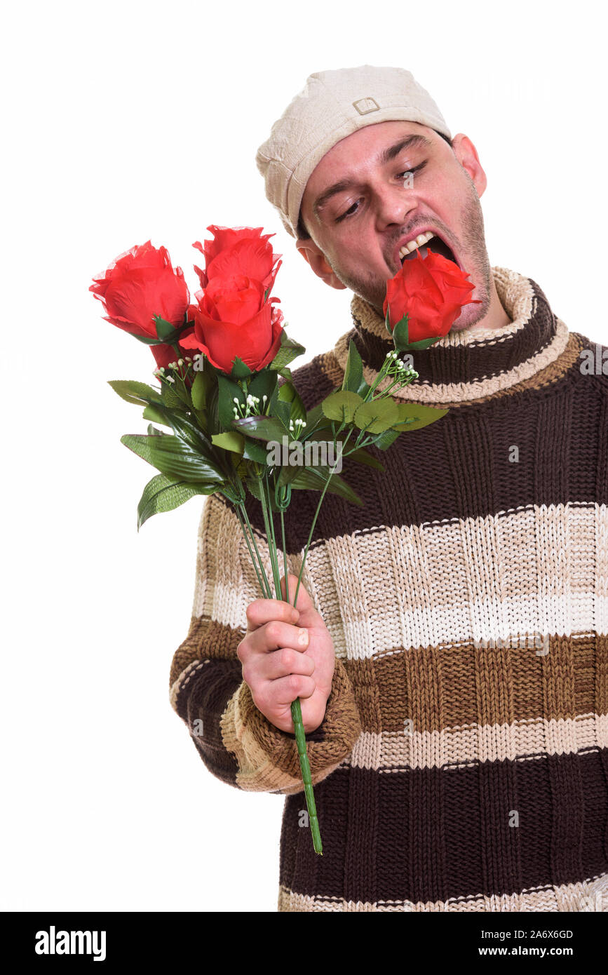 Studio shot of young man eating red roses Stock Photo - Alamy