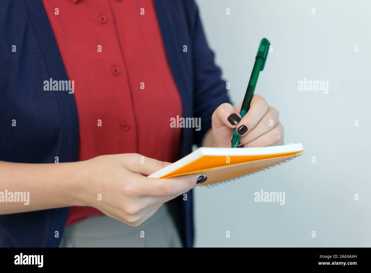 Young caucasian girl woman taking notes in notebook clipboard, close up ...