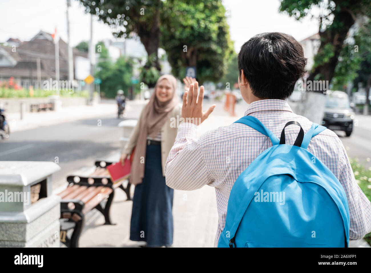 portrait of teenage student smiling and say hello to her friend Stock ...