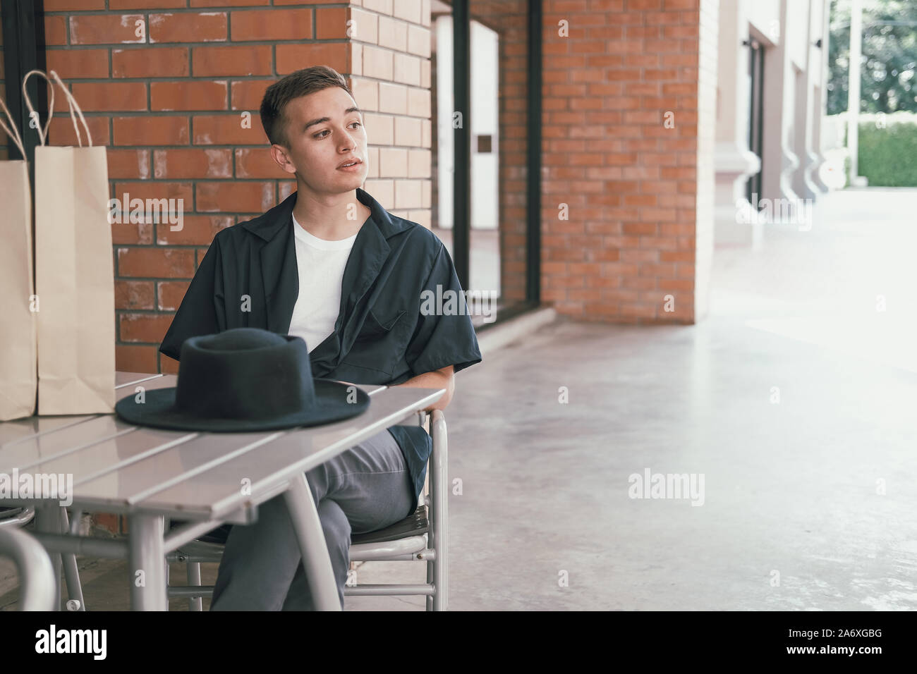 man sitting resting with shopping bags at shopping mall. consumerism ...