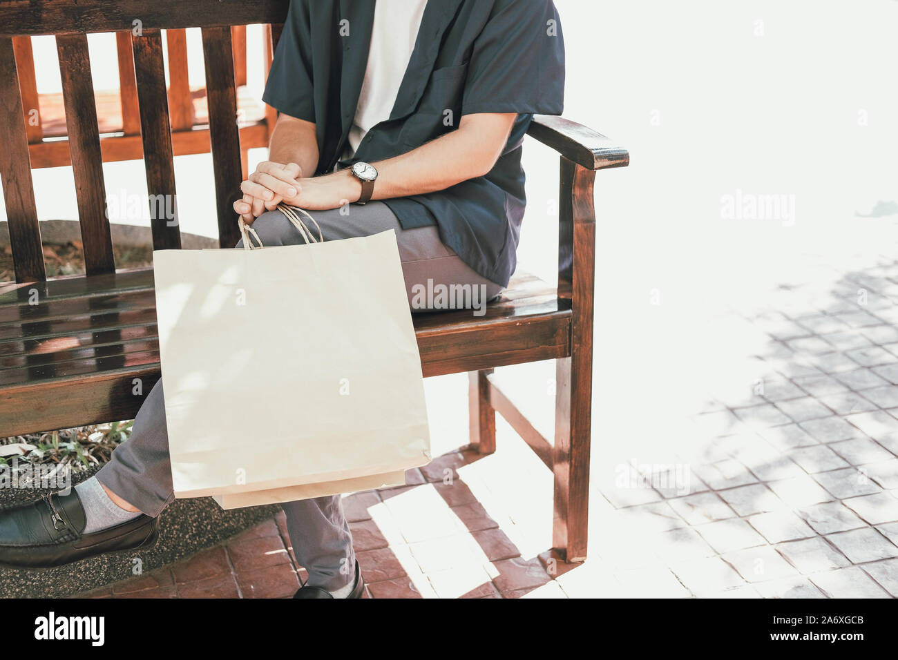 man sitting resting with shopping bags at shopping mall. consumerism ...