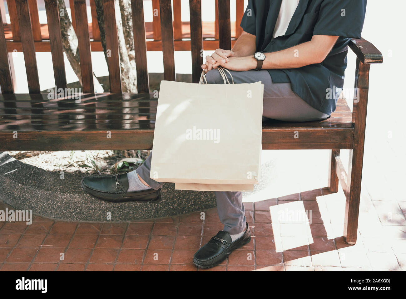 man sitting resting with shopping bags at shopping mall. consumerism ...