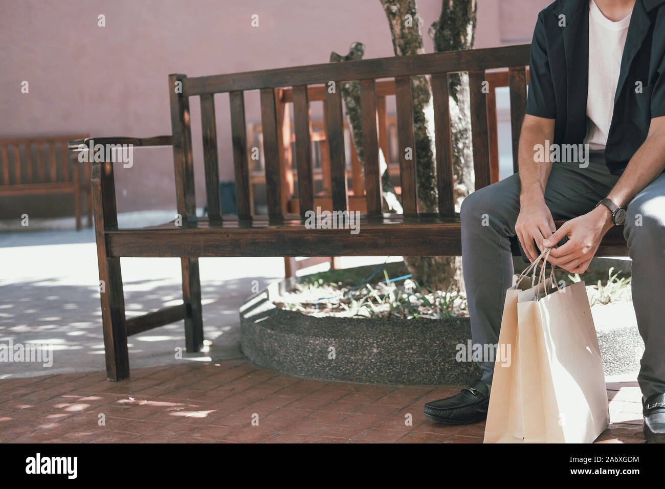 man sitting resting with shopping bags at shopping mall. consumerism ...