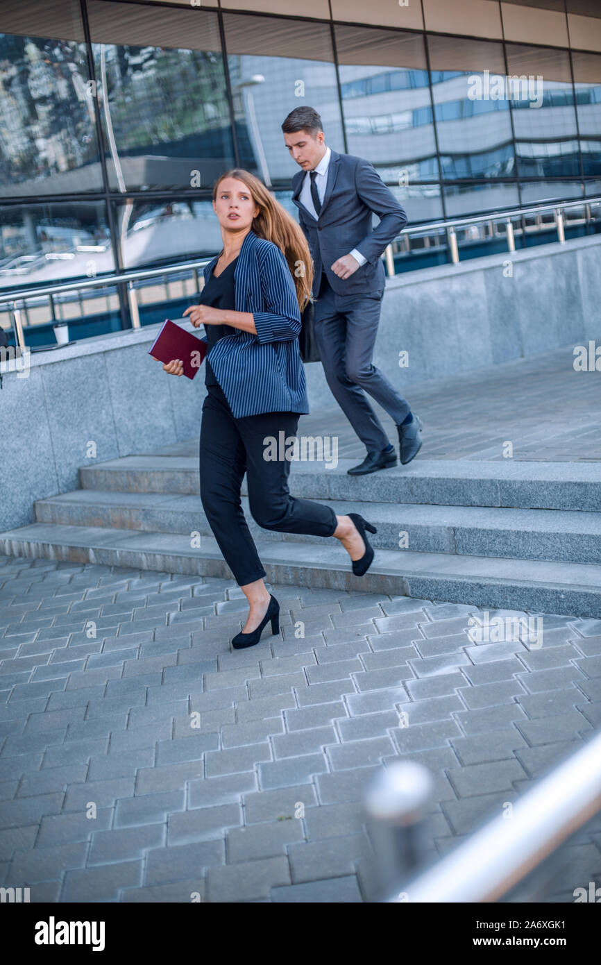 two young employees in a hurry somewhere Stock Photo - Alamy