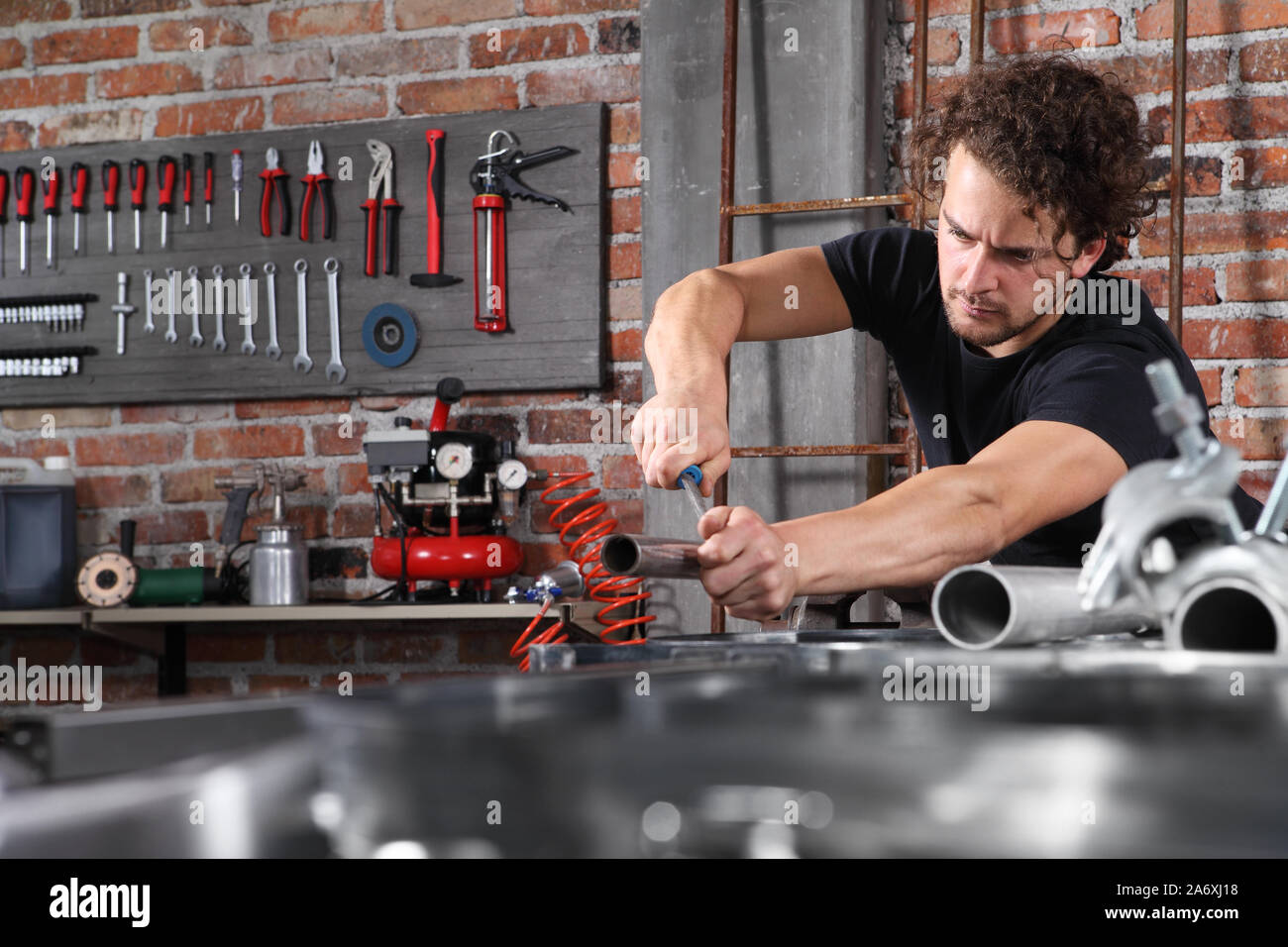 man work in home workshop garage with steel file rasp, filing metal ...