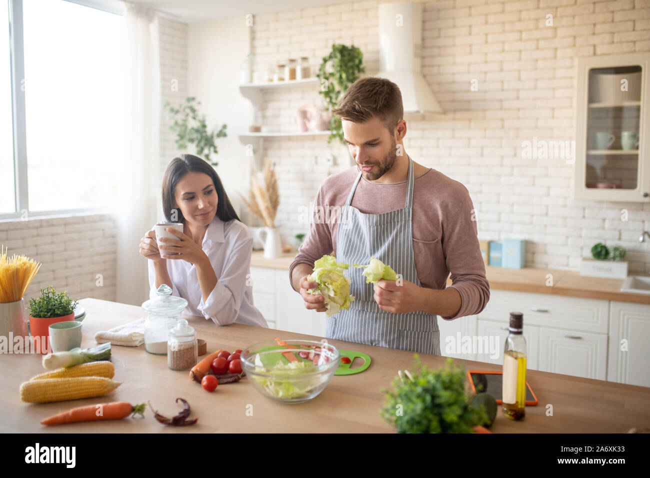 Bearded husband taking lettuce while cooking salad for wife Stock Photo ...