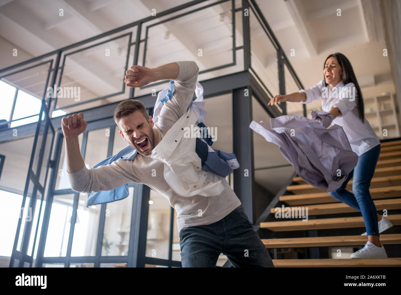 Wife throwing away clothes of her husband Stock Photo - Alamy