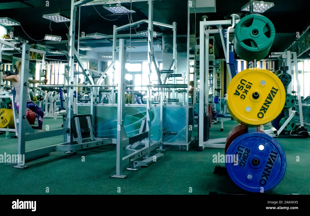 Professional red, green, blue dumbbells and weight plates on the ...