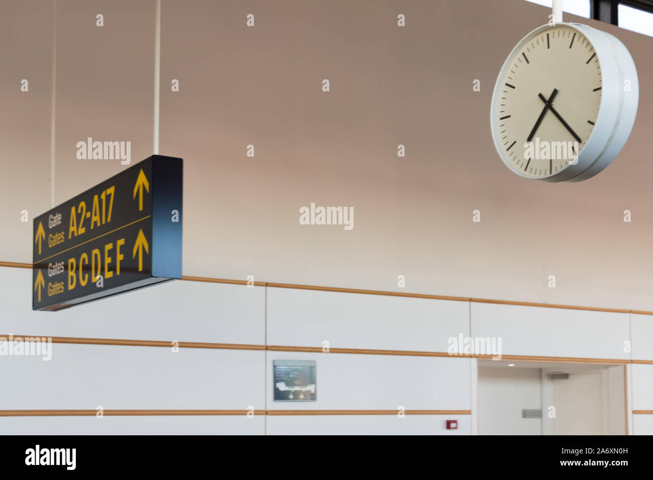 A panel indicating the boarding gates and a clock inside an airport ...