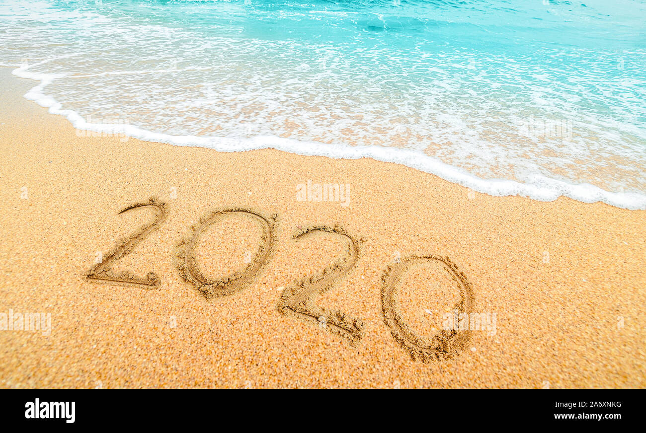 Happy New Year 2020, lettering on the beach with wave and blue sea ...