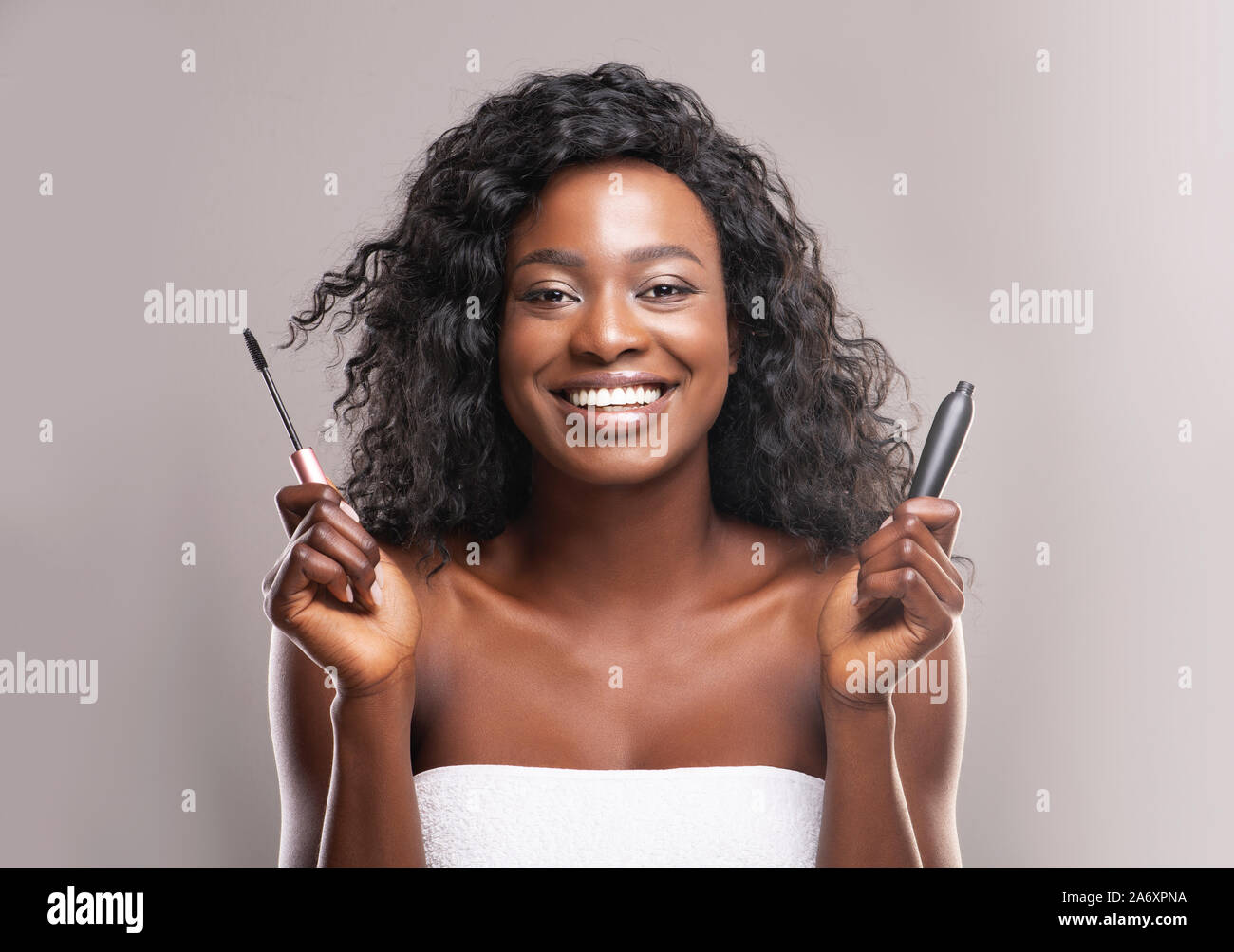 Beautiful african american woman holding opened mascara in her hands ...