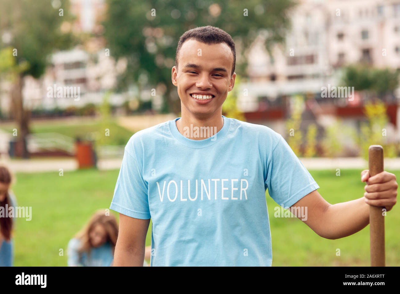 Volunteering. Young people volunteers outdoors planting trees guy ...