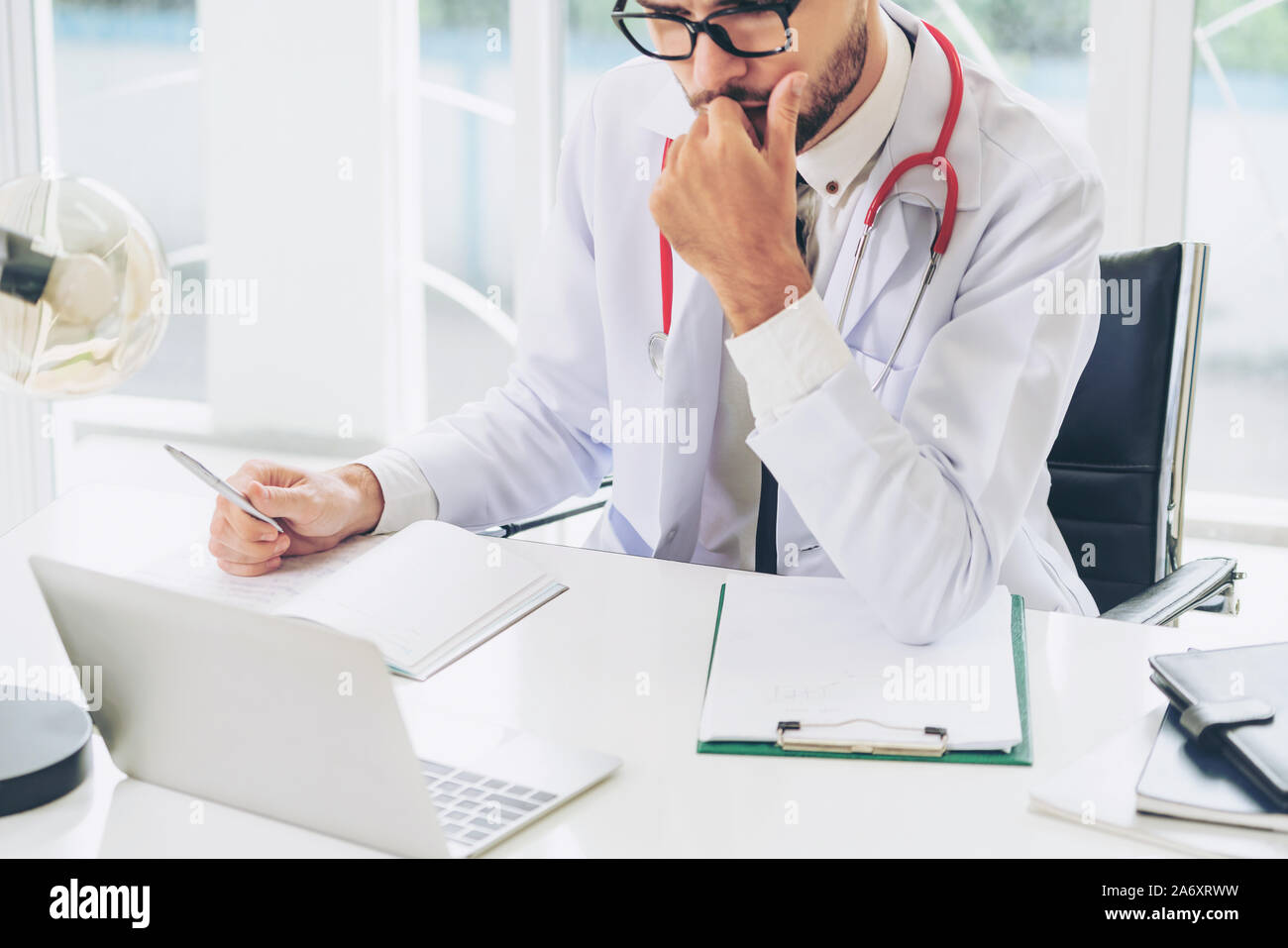 Doctor working on laptop computer at office table in the hospital ...