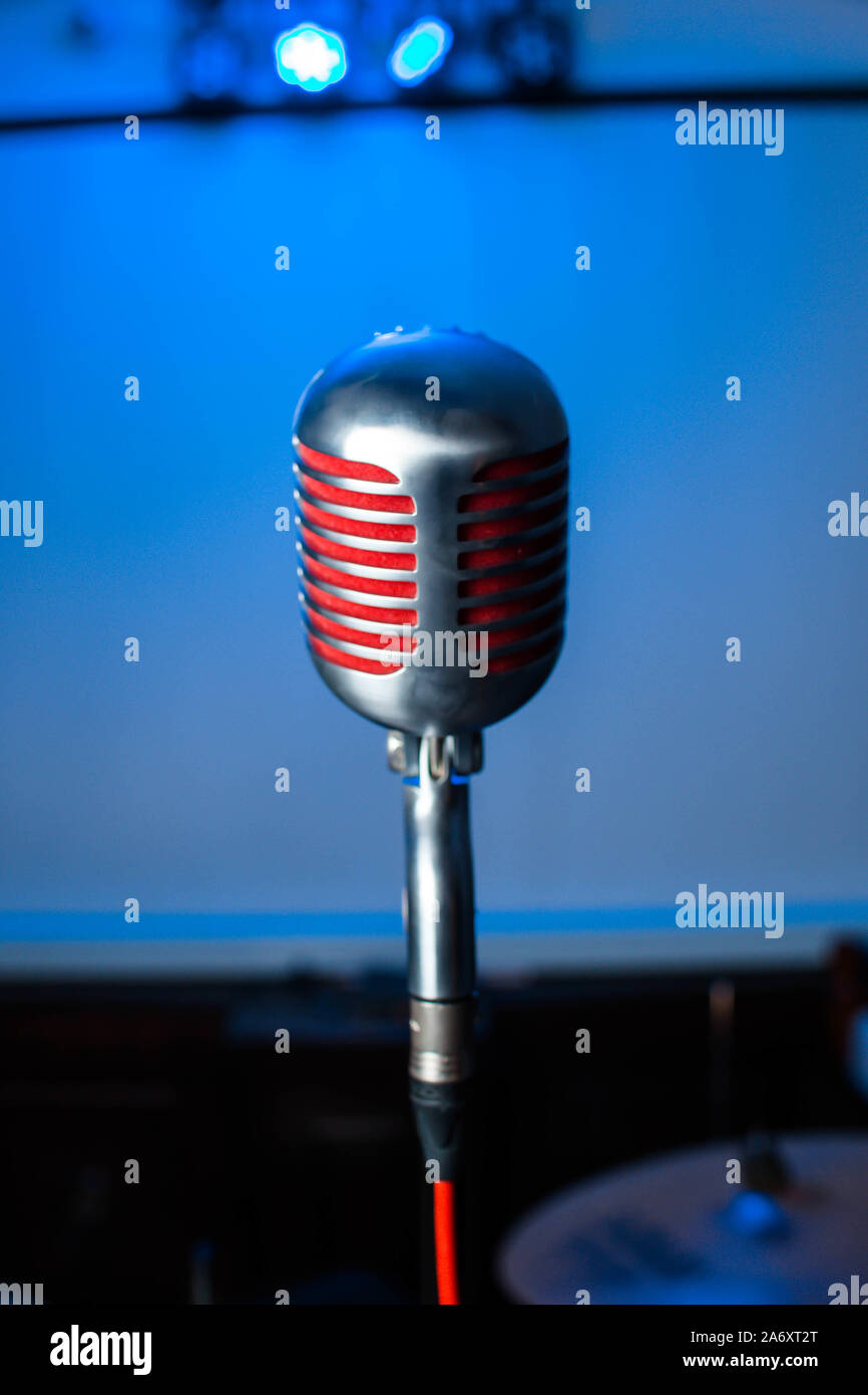 Microphone is on stage in a nightclub. Singer holds and sings into the ...