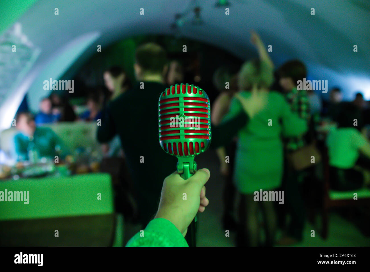 Microphone is on stage in a nightclub. Singer holds and sings into the ...