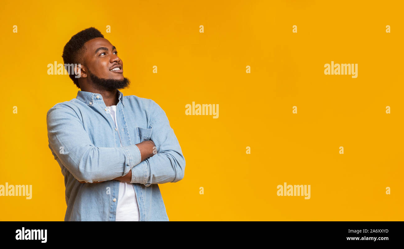 Interested man looking upwards at copy space on yellow background Stock ...