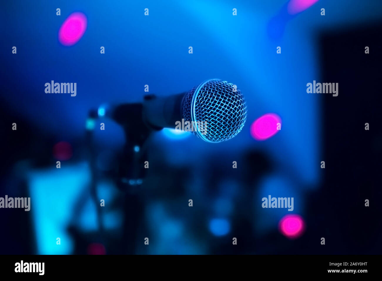 Microphone stands on stage in a nightclub. Bright club light shines on ...