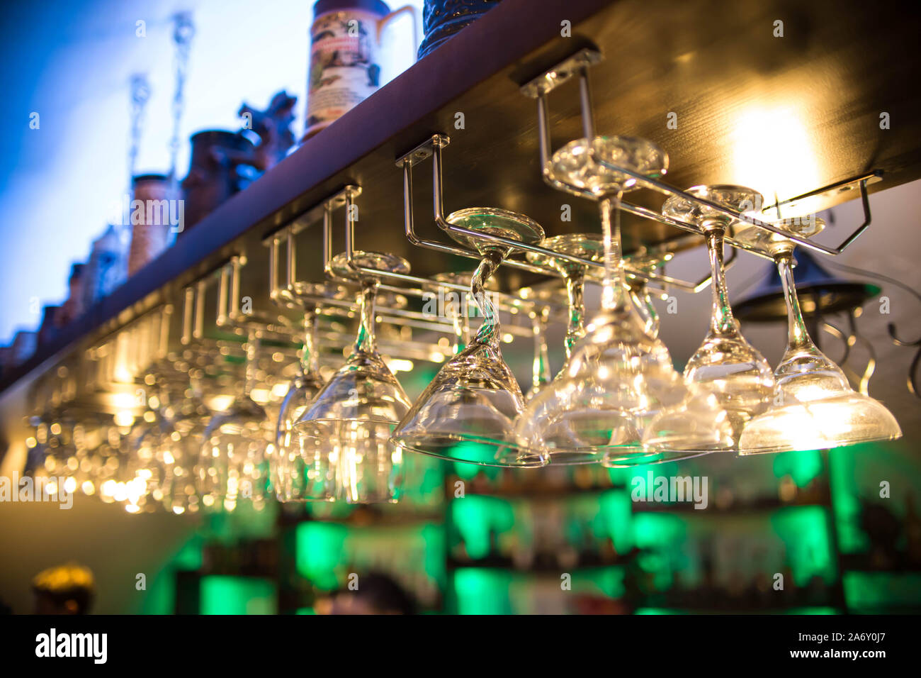 Beautiful cocktail glasses in the bar hang over the table. Nightclub ...