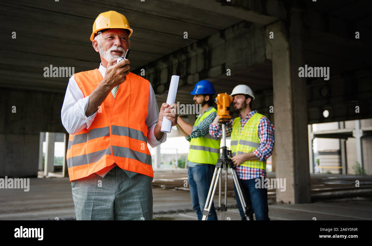 Two satisfied engineers talking at building site with construction ...