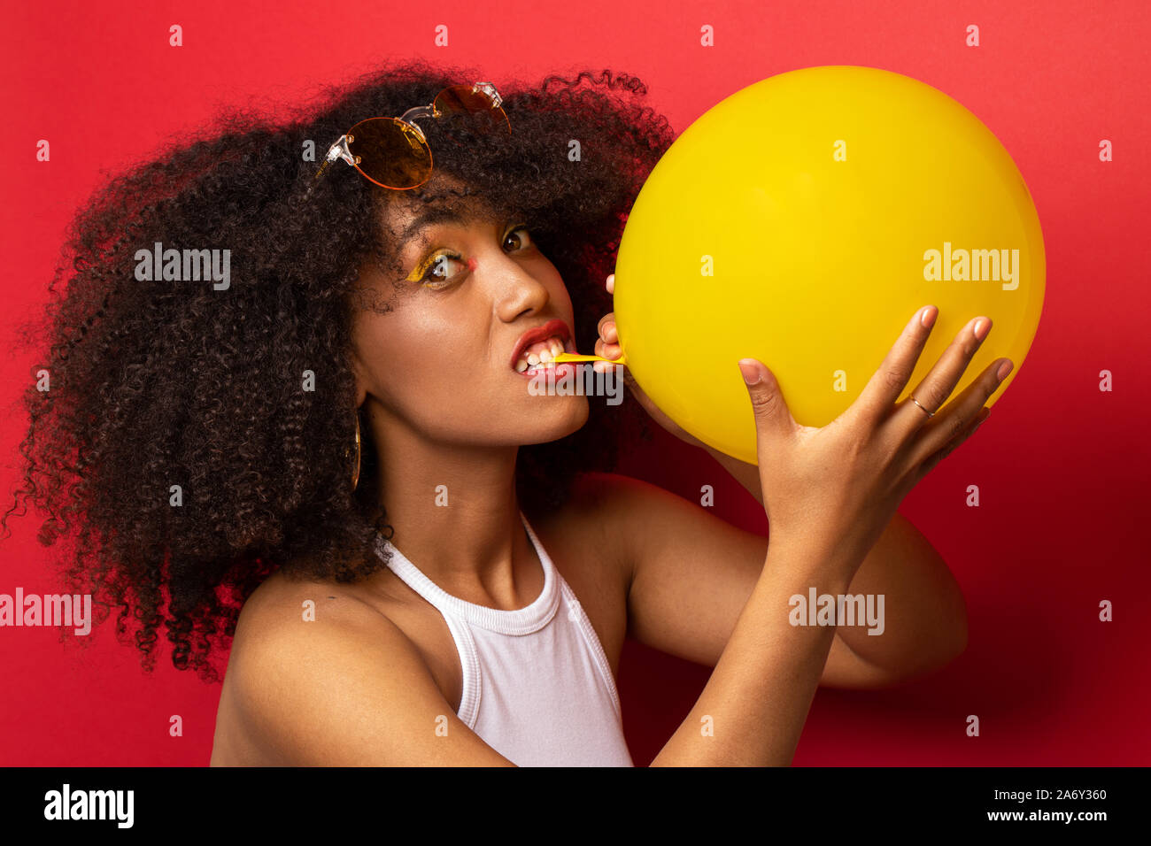 model with curly hair inflates the balloon Stock Photo - Alamy