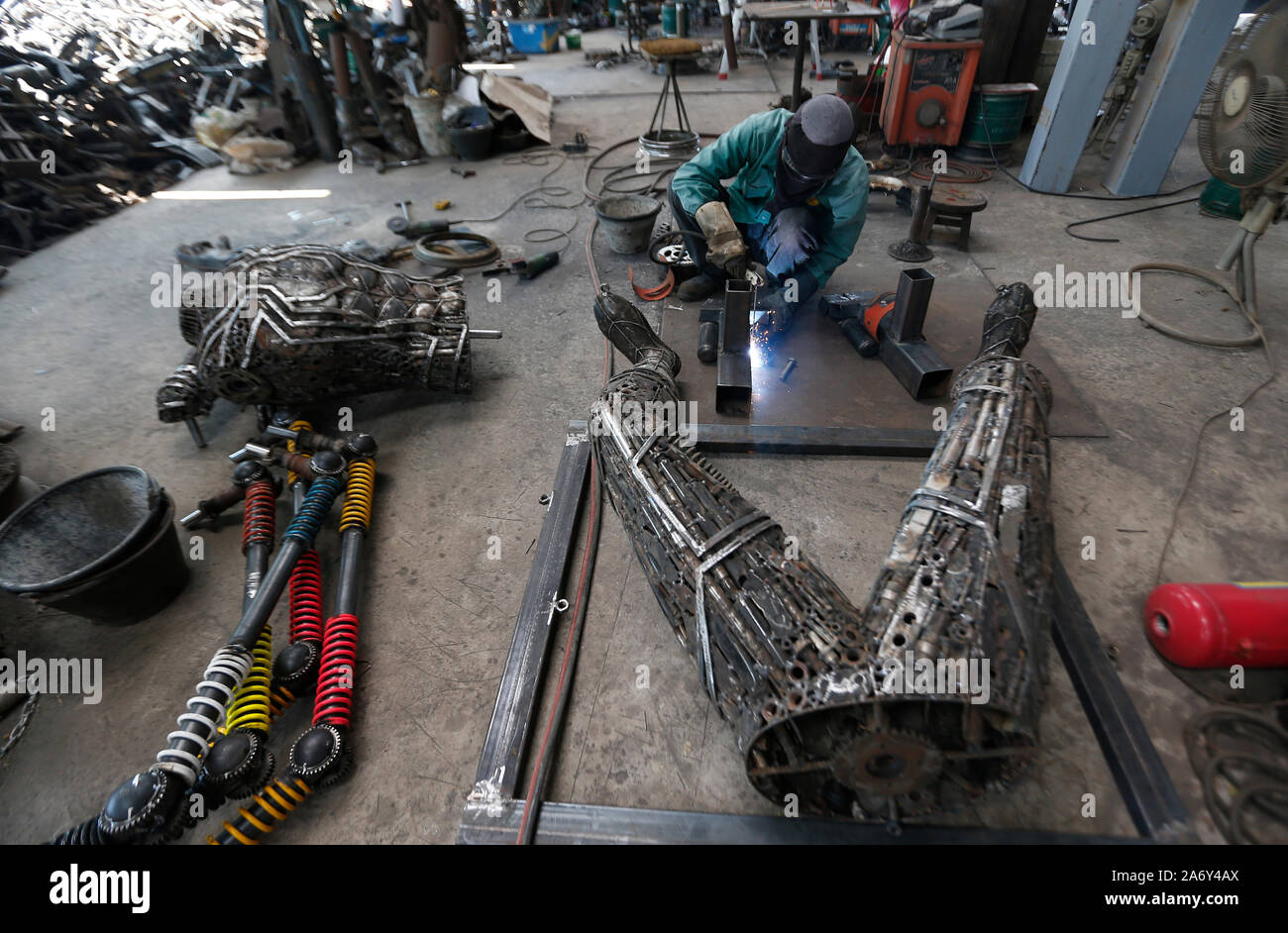 A metalworker seen welding a statue of Transformers at Ban Hun Lek, a ...