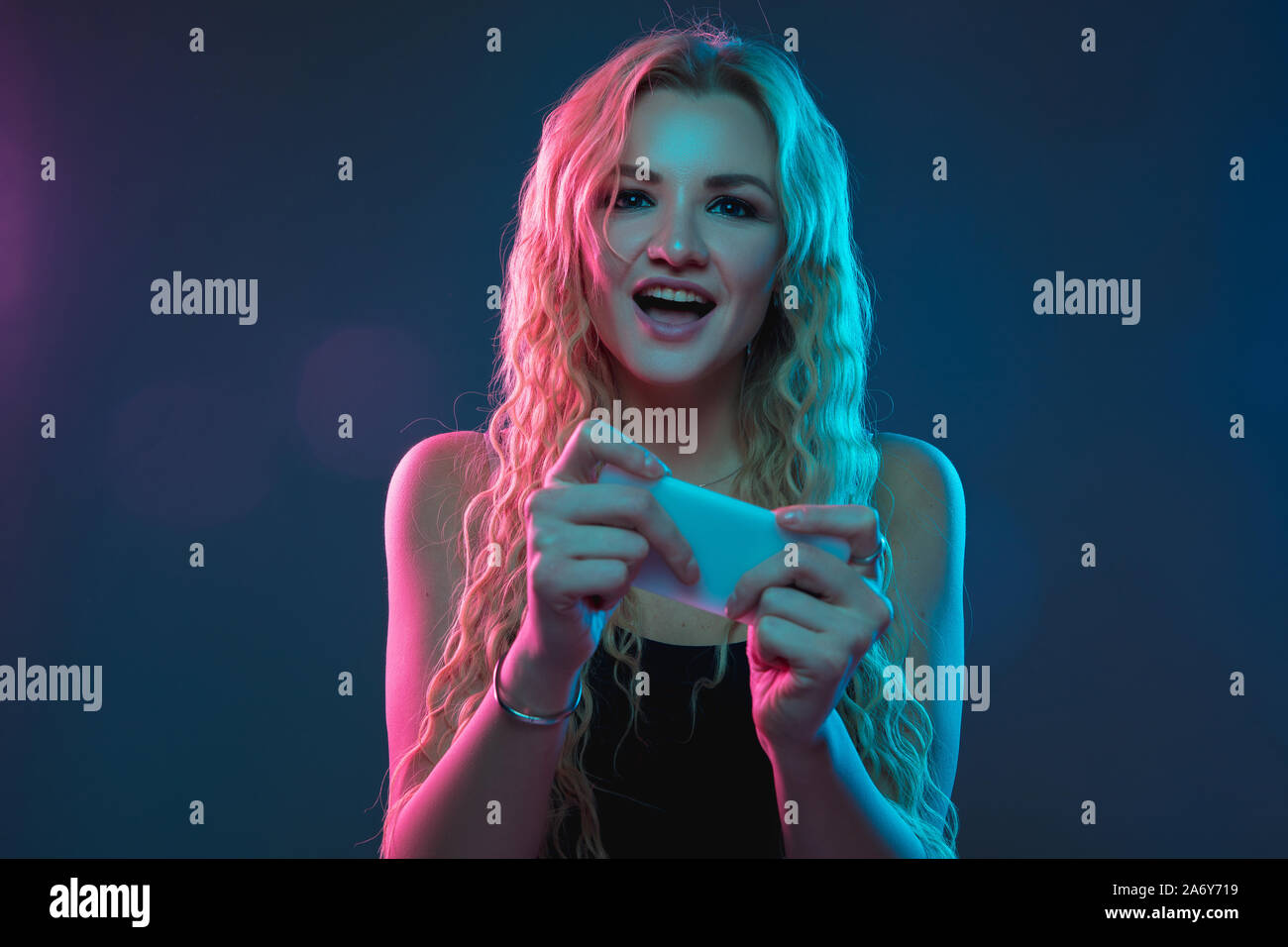 Caucasian young woman's portrait on gradient background in neon light ...