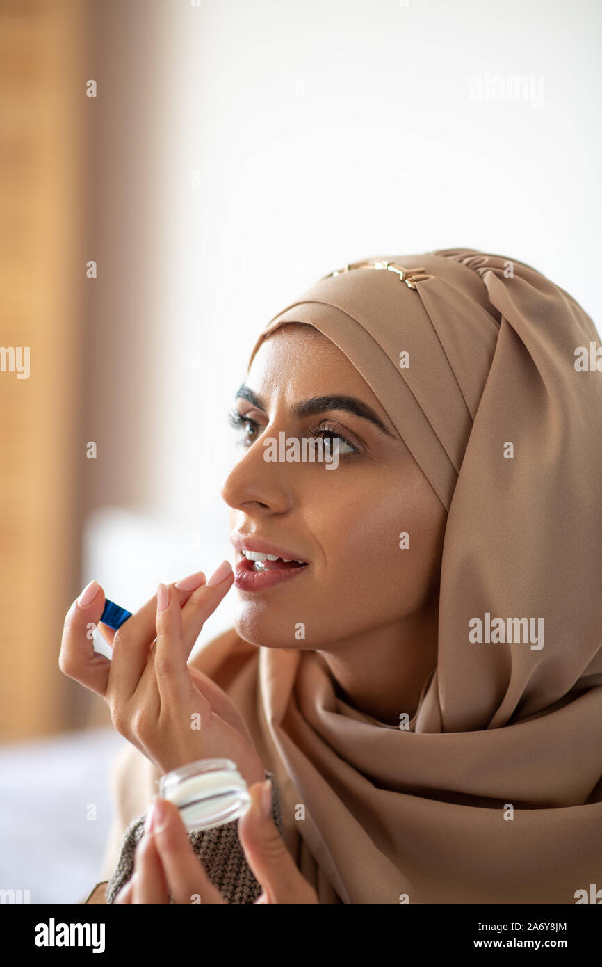 Young girl wearing hijab using lip balm in the morning Stock Photo - Alamy
