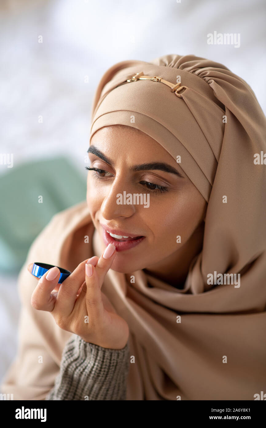 Pretty girl using lip balm to keep her lips hydrating Stock Photo - Alamy