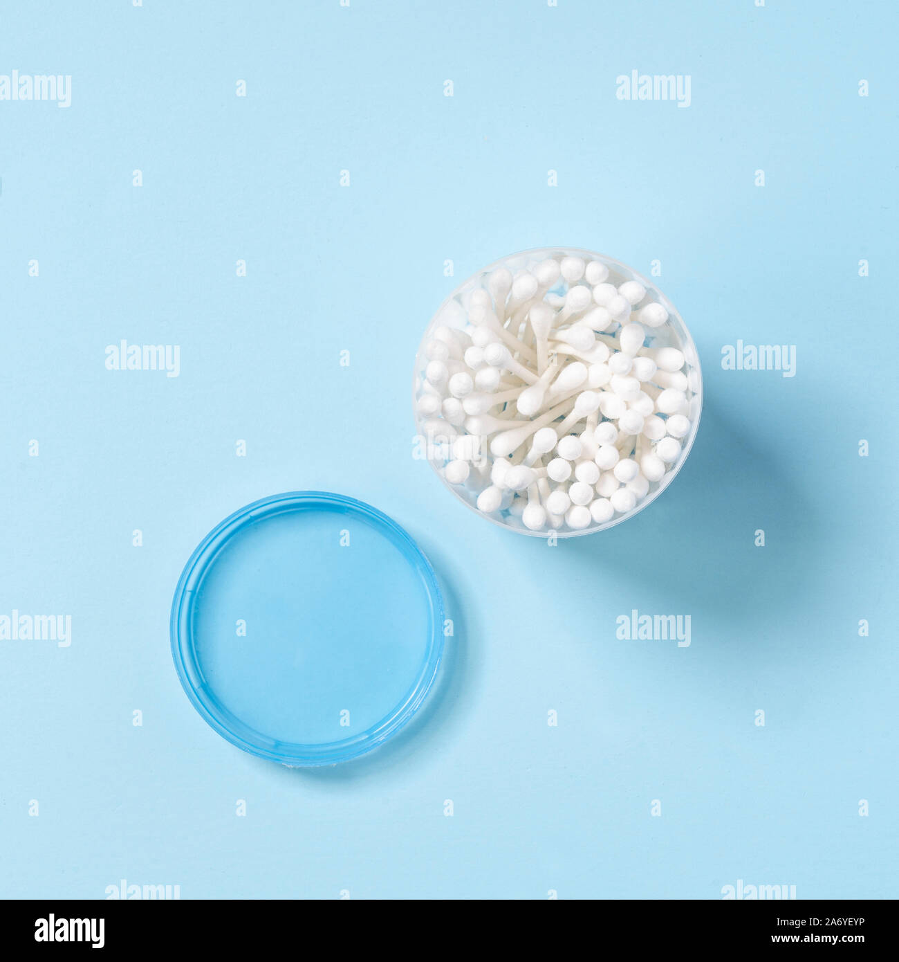 some cotton swabs in a container on a blue surface Stock Photo - Alamy