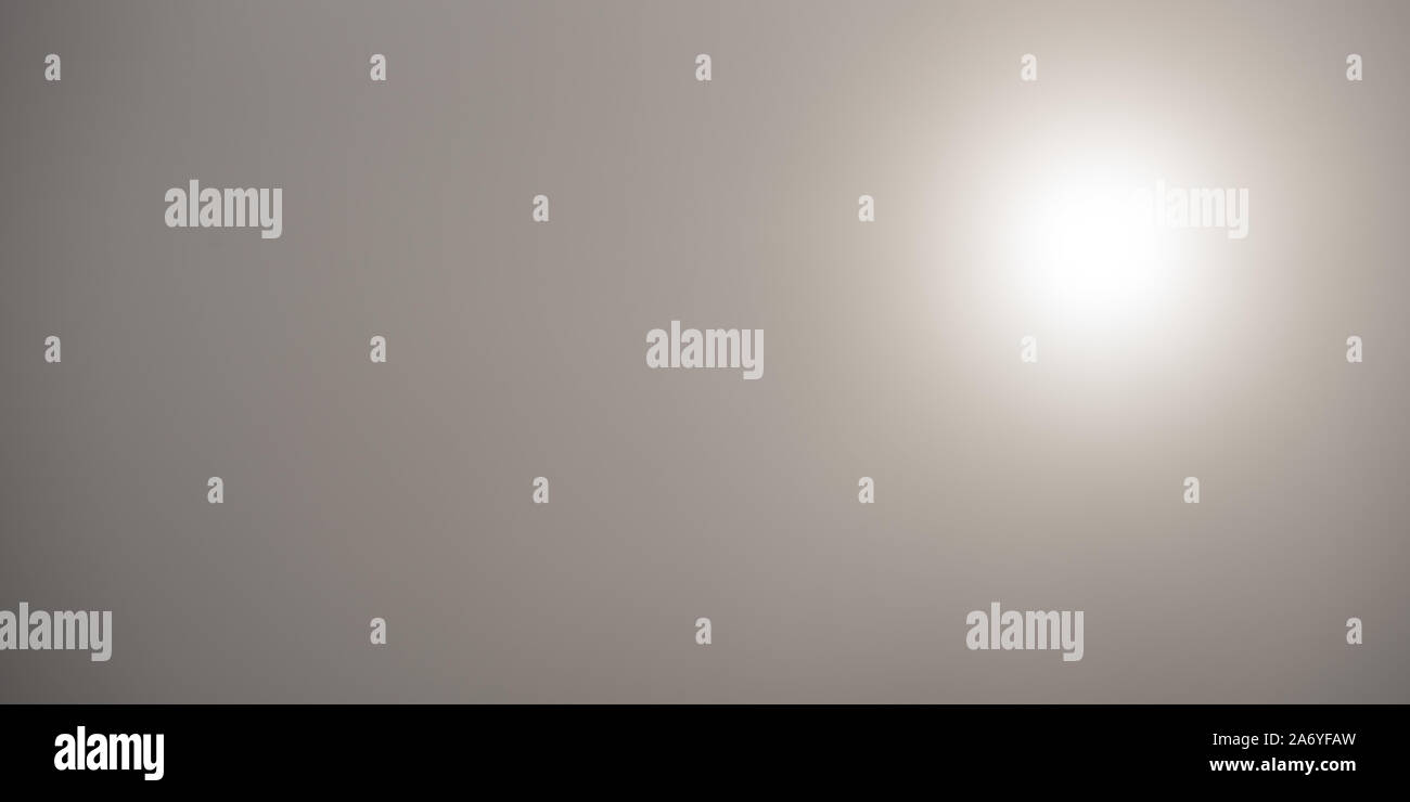 Sun hidden in the sky behind fog Stock Photo - Alamy