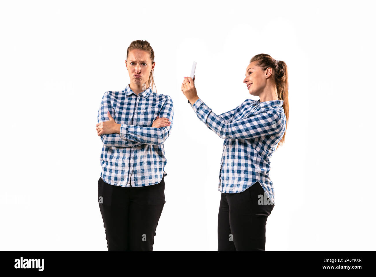 Young handsome woman arguing with herself on white studio background ...