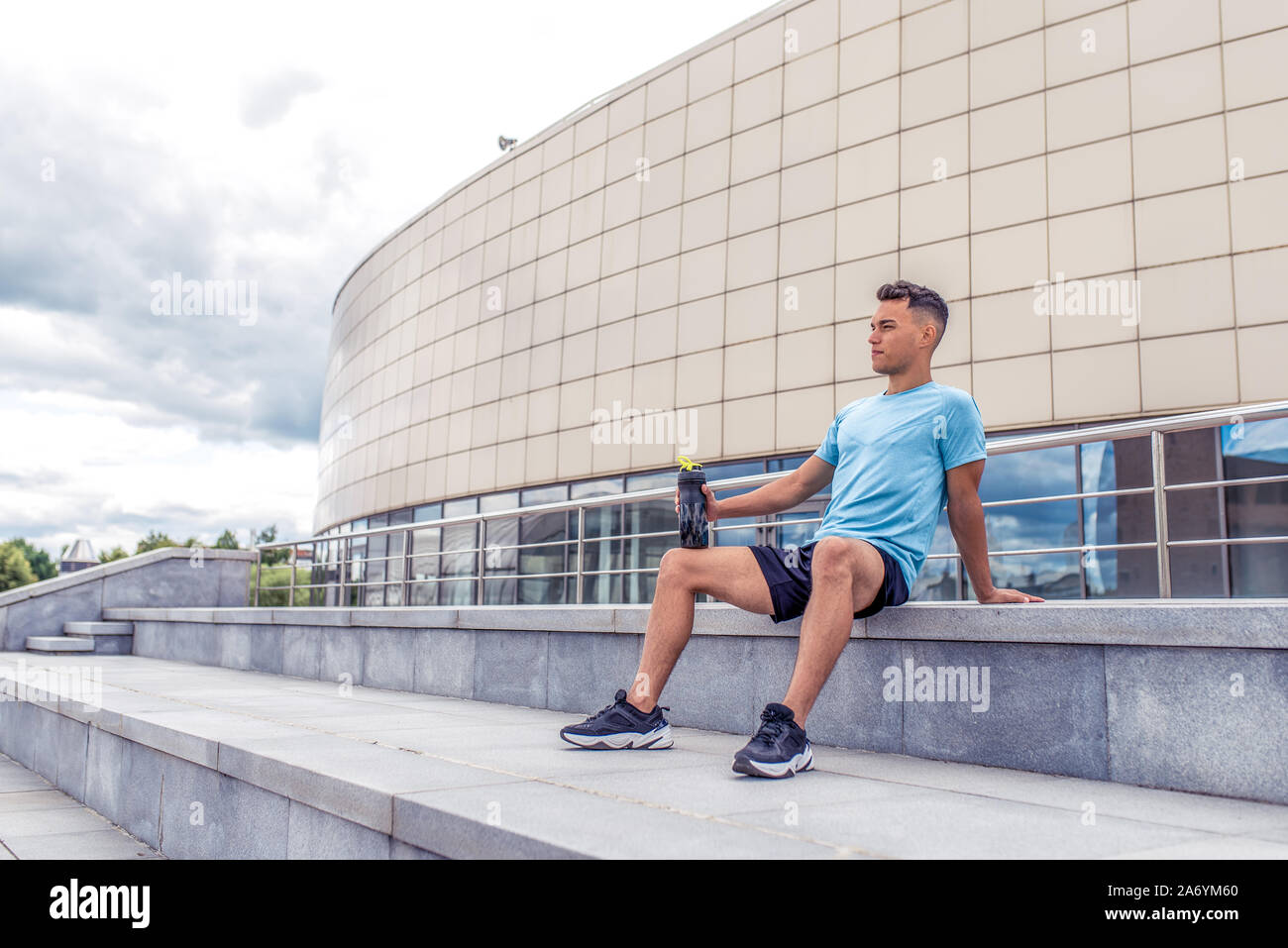 sports man resting after hard workout, shaker with protein and water, a ...
