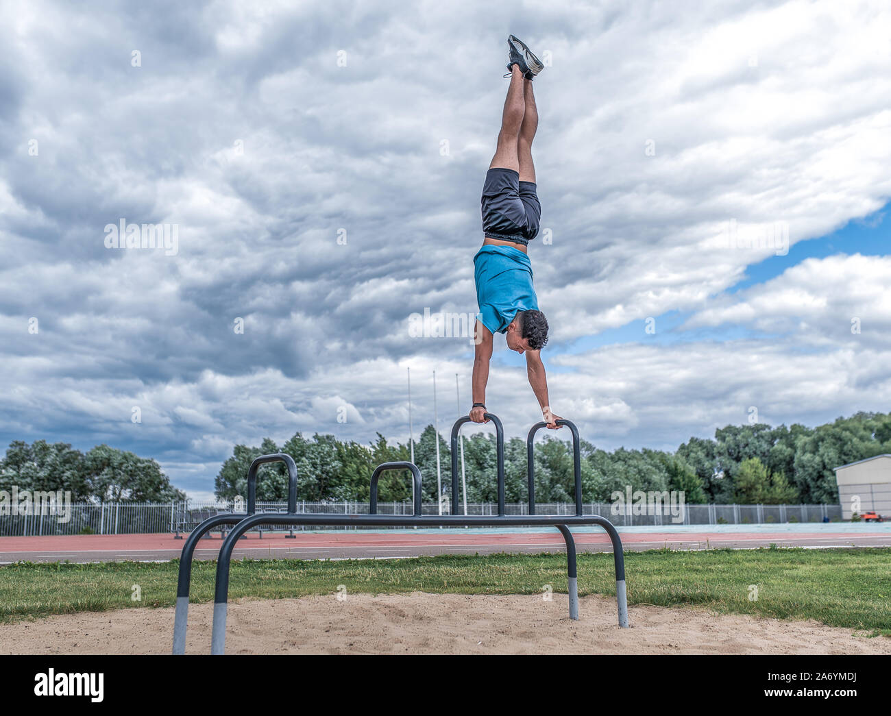 sports man handstand, balance, push-ups horizontal bar, exercise in ...