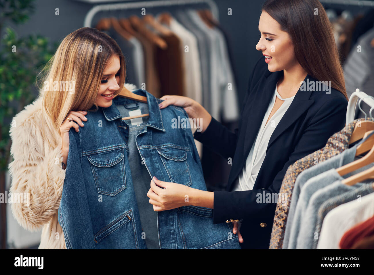 Shop assistant helping customer in boutique Stock Photo - Alamy