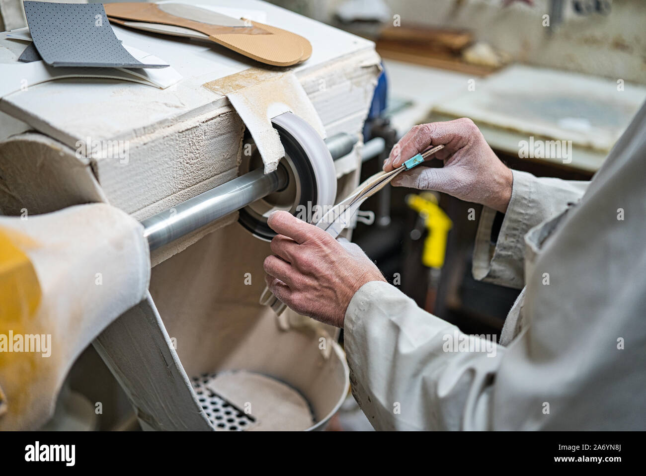 Professional craftsman of orthopedic insoles polishing, sanding and ...