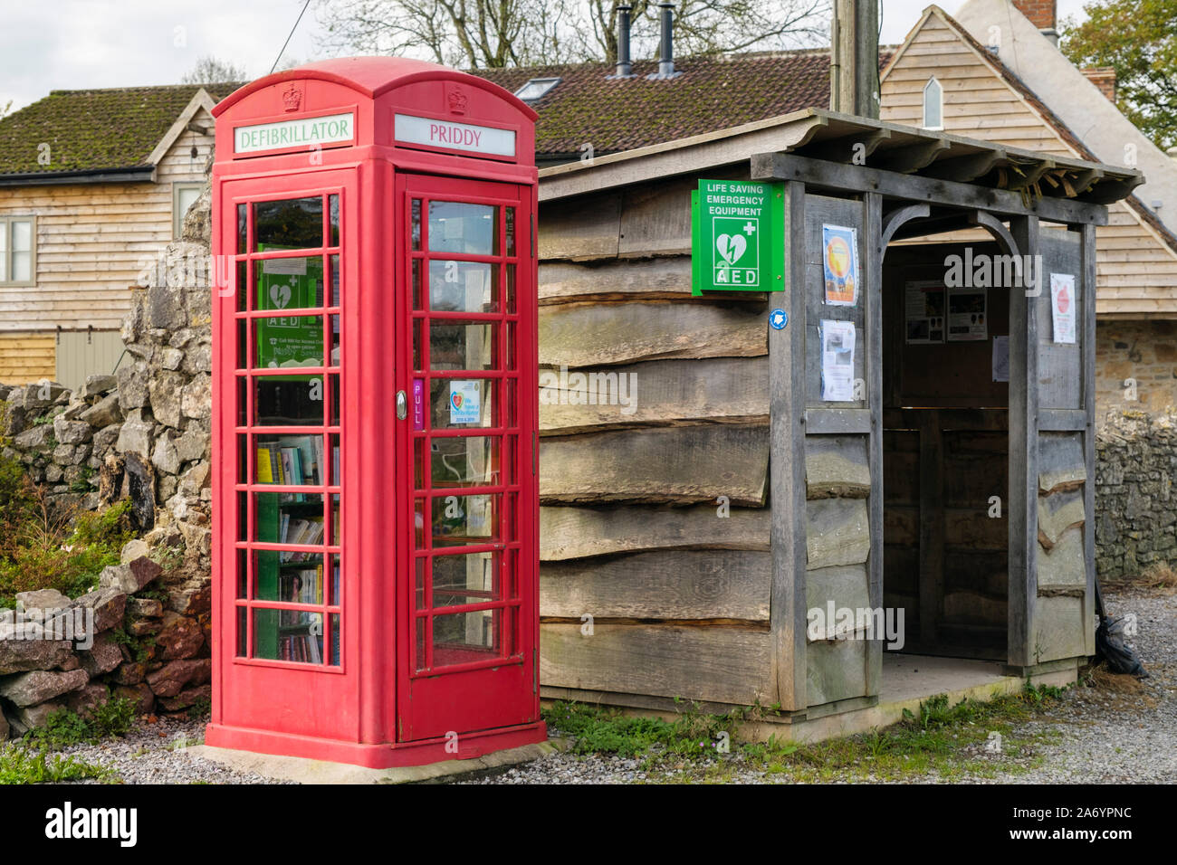Traditional red public telephone box with a defibrillator and book ...