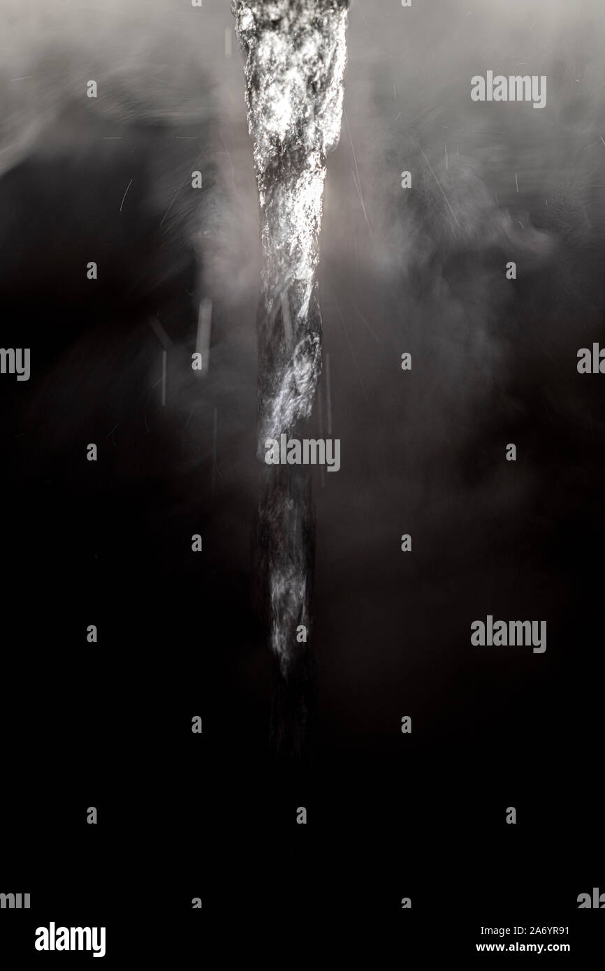 Close up of boiling water flowing from a tap with mists of water vapour ...