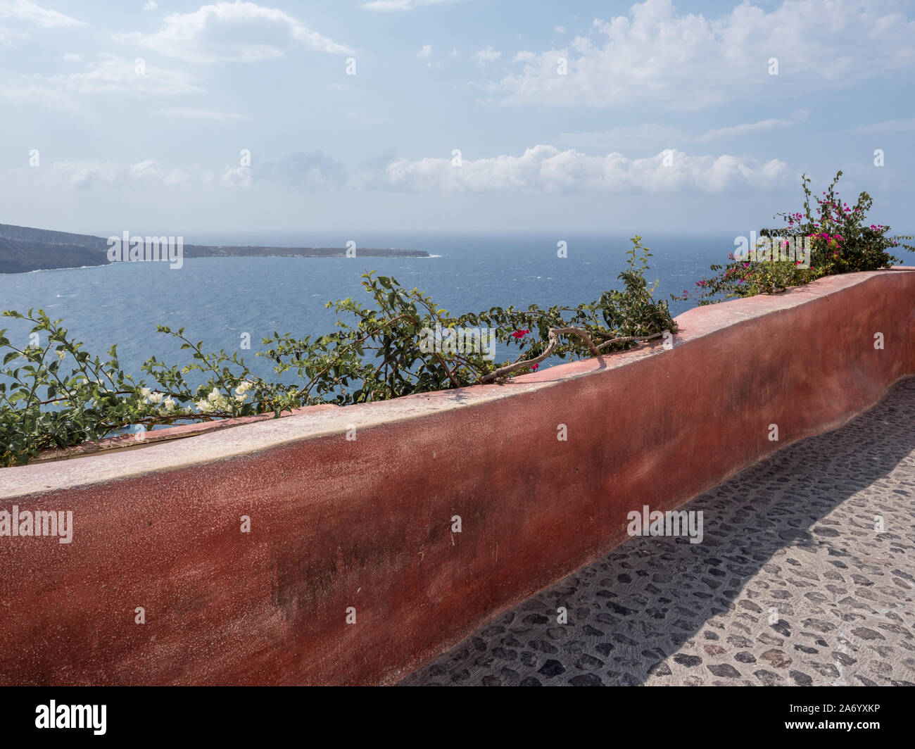 a long earthy red diagonal wall and cobbles stone cobblestones ground ...