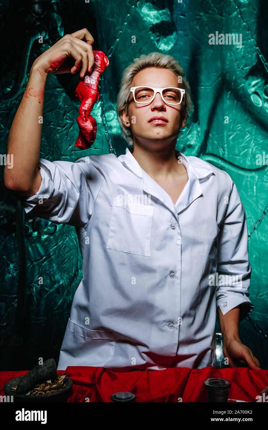 mad medical scientist in doctor's robe eats raw meat and enjoys ...