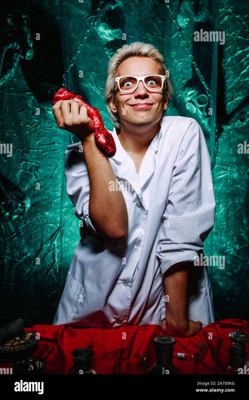 mad medical scientist in doctor's robe eats raw meat and enjoys ...