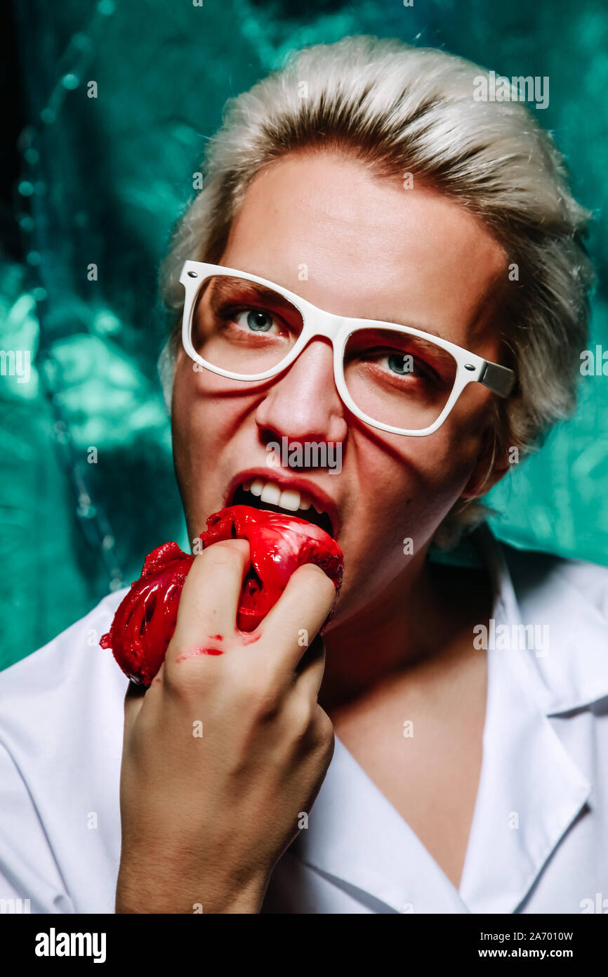 mad medical scientist in doctor's robe eats raw meat and enjoys ...